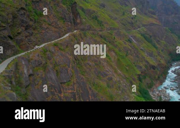 Aerial top down view 4wd vehicle drive on narrow dangerous gravel road ...