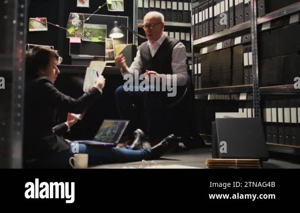 Law officers review case files in incident room, reading confidential ...