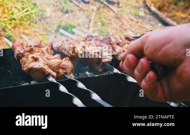 Kebab is fried on skewers in the grill and turned over. Juicy beautiful ...