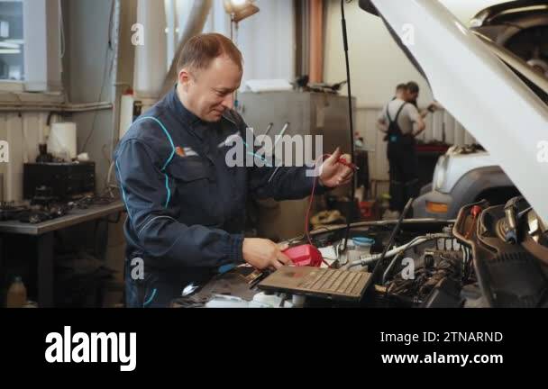Professional mechanic doing a car inspection, he is testing a car ...