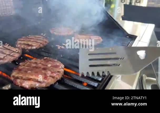 steak bbq burger patties fry over an open fire on the grate flip flame ...