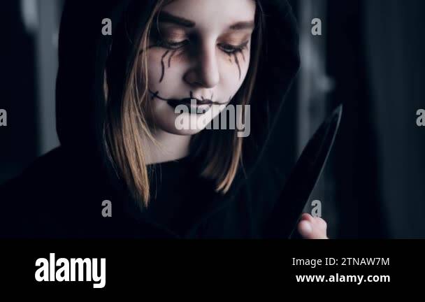 Spooky preteen girl with knife in black and Halloween dark makeup ...