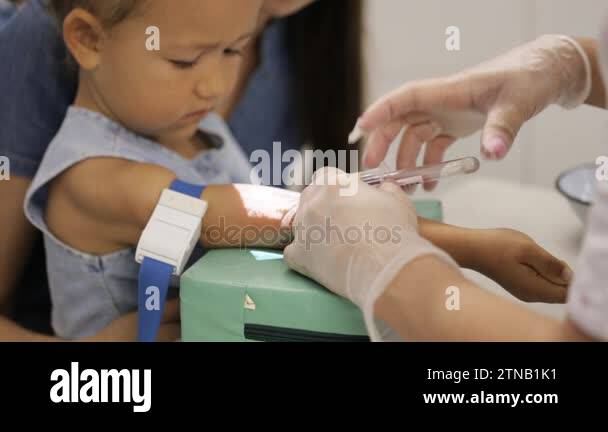 Little girl with mother in hospital. Nurse taking girls venous blood ...