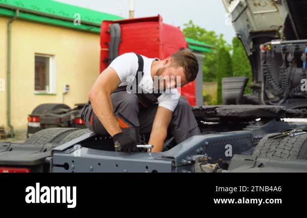 Semi Truck Under Maintenance. Caucasian Truck Mechanic Working to Fix ...