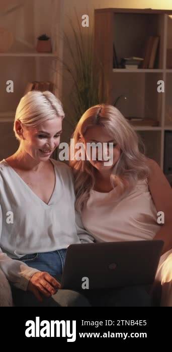 Vertical video. Family online leisure. Internet relaxing. Smiling mother daughter using laptop ...