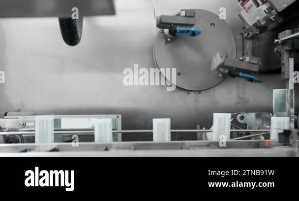 Manufacturing line at medical factory. Robotic arm put medicine package ...