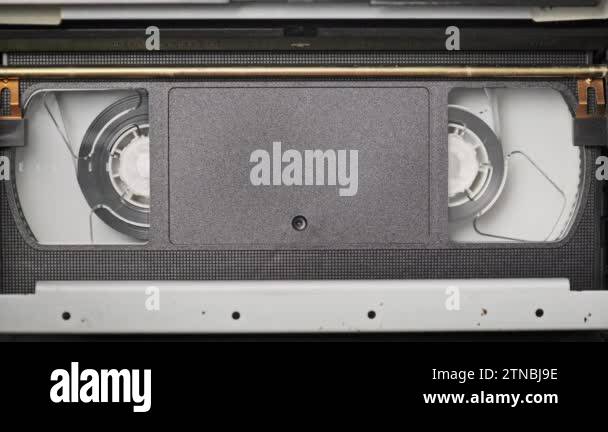 VHS video tape putting inside a VCR recorder and plays. Vintage VHS ...