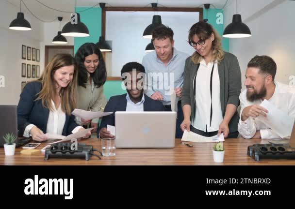 Real time group of happy multiracial coworkers looking at netbook and ...