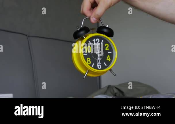 Loudly ringing retro alarm clock in the hand of a man. Time to get up ...