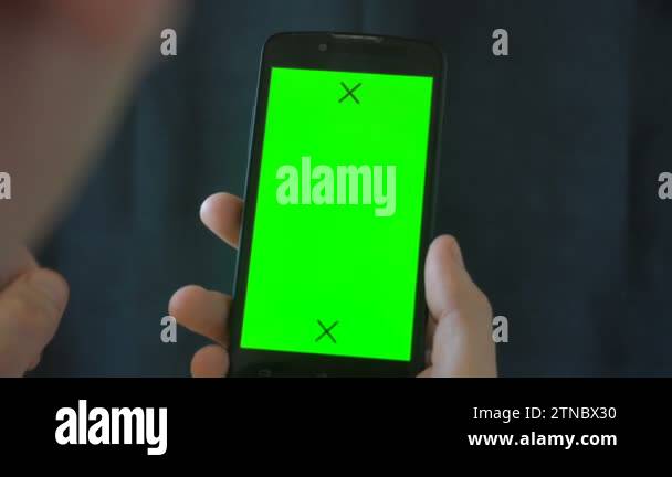 Close-up of male hands touching of smartphone. Green screen Chroma Key ...