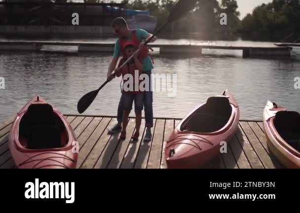 The father teaches the son how to use an oar in a kayak Stock Video ...
