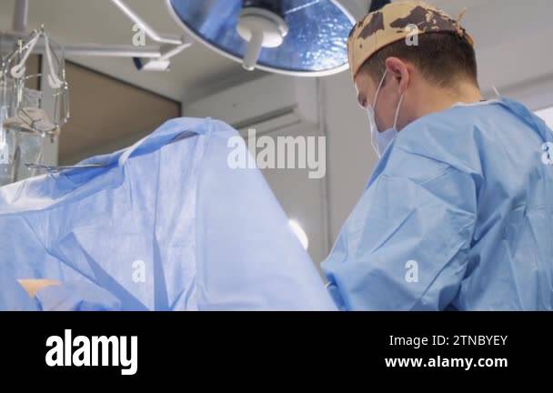 Professional young experienced surgeon during operation in operating ...