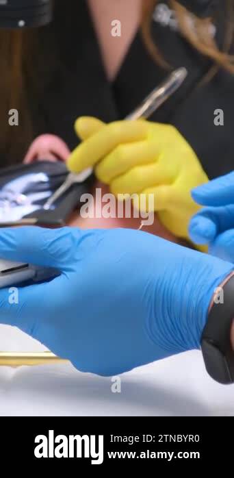 Dentistry hands of doctor and paramedic assistant in yellow and blue ...