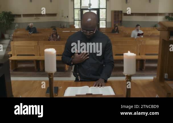Young adult African Amerian pastor standing in front of altar in ...