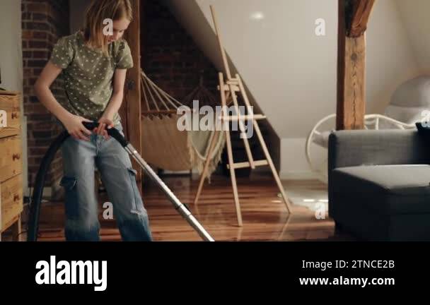 Girl child cleaning carpet with vacuum cleaner from dust at home ...