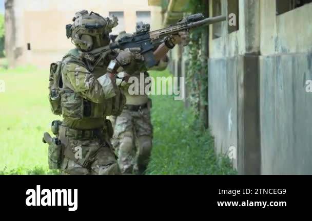 Smart teamwork of soldiers walking forward and attacking enemy during ...