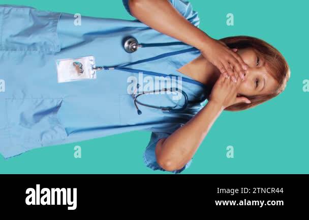 Experienced nurse covering mouth with hands, holding back from saying ...