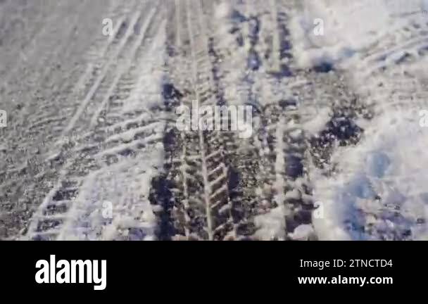 Tire tracks visible on a thin layer of white snow. A cold winter day ...