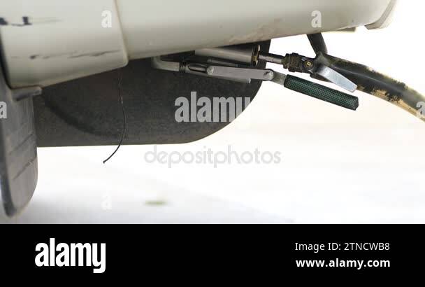 Fuel nozzle inserted in car's gas tank as it's being refueled at gas ...