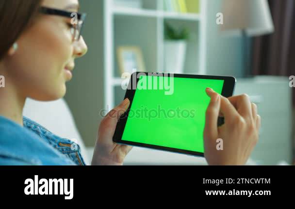 Attractive young woman using black tablet computer with green screen ...