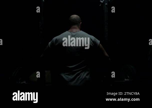 Handsome weightlifter training. Confident muscular man training squats ...