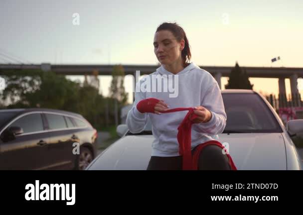 Female boxer unwrap hands after training outdoor gym or fitness center ...