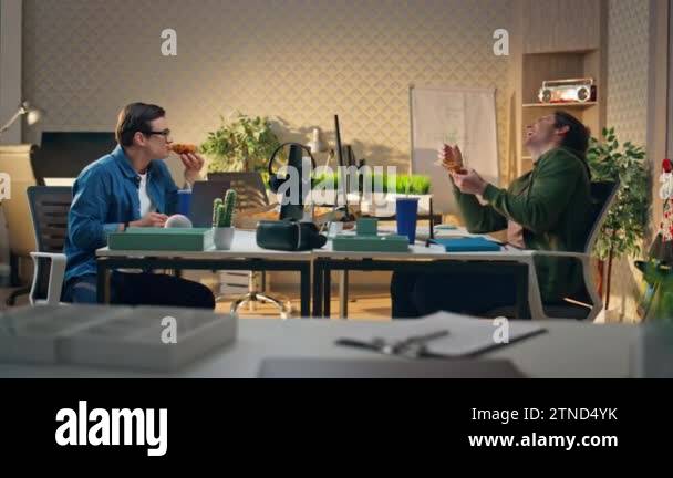 Excited partners tasting food joking at open space. Two laughing guys ...