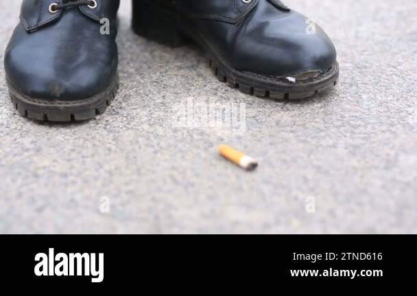 A man in torn, tattered boots on lacing stands in the middle of the ...