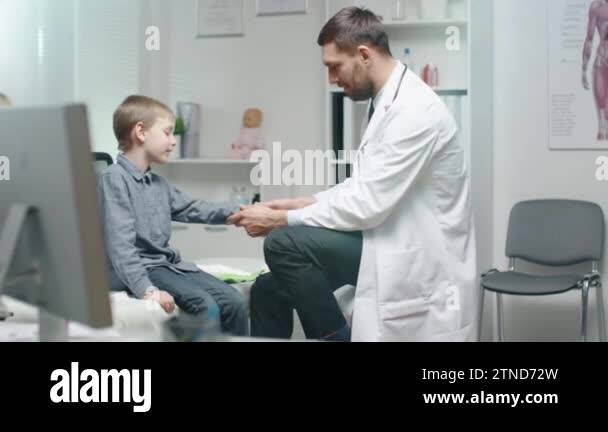 Male Doctor Checks Young Boys Muscle Tone in Hands. After Check-up They ...