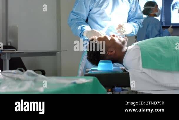 African american male surgeon giving anesthesia to patient in operating ...