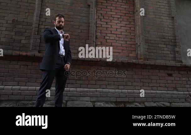 Distracted businessman pulling out his mobile phone from his pocket as ...