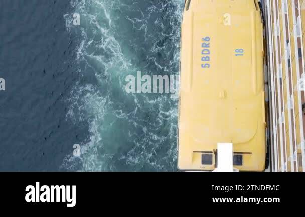Lifeboat on giant cruise ship view down to ocean surface with waves ...