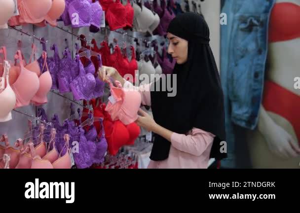 Muslim woman customer, female client in lingerie store chooses pink ...