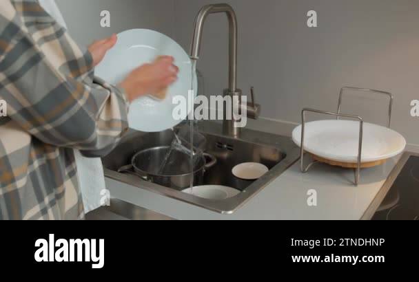 young woman concentrated on washing dishes at home Slow motion Daily ...