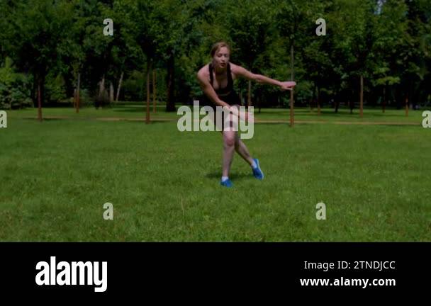 Active motivated charming fit middle aged woman in sportswear practicing skater lunges exercise ...