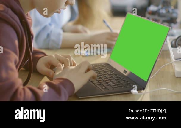 Smart Young Boy Works on a Laptop with Mock-up Green Screen in His Computer Science Class Stock ...