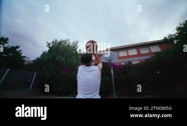 Basketball player shoot ball into hoop and keep focus on rim. Cinematic ...