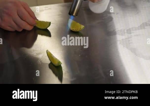 Chef burns slise of lime. Set fire to the slice of lime, lyme. Slice of ...