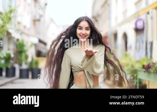 Beautiful young indian woman makes a beckoning gesture with one finger ...