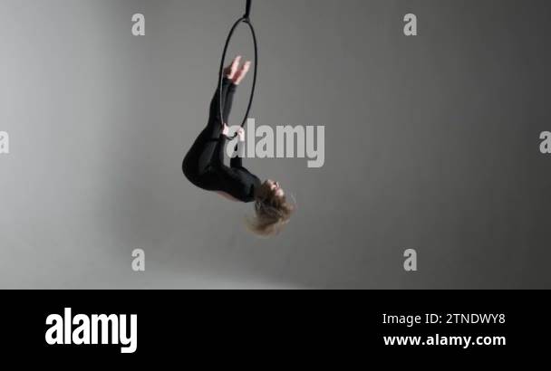 against a dark background, a caucasian dancer clad in a sleek black ...