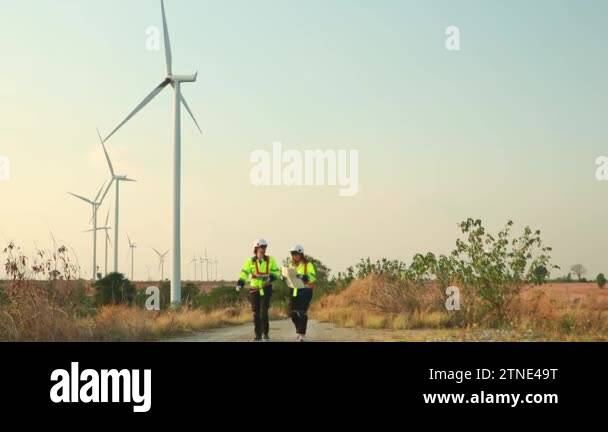 Two caucasian engineers and technicians walk out of the wind turbine ...