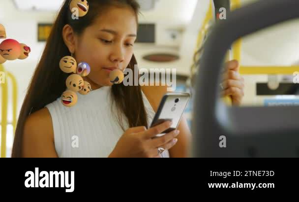 Animation of multiple emoticons over asian woman using cellphone while ...