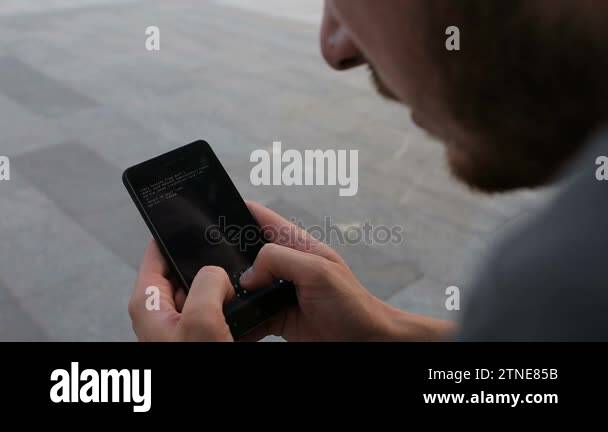 Hacker breaks into a wifa using a phone in the park on the bench Stock ...