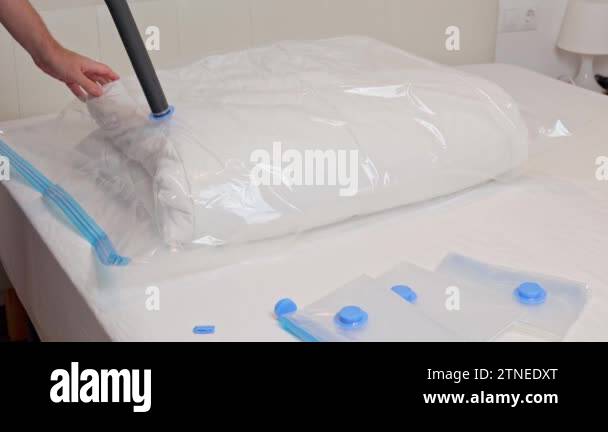 Cropped shot of unrecognizable man sucking air from compression bag ...