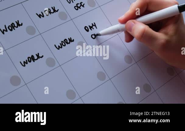 Unrecognizable person write on Magnetic board 4 day work week calendar with three weekend days ...