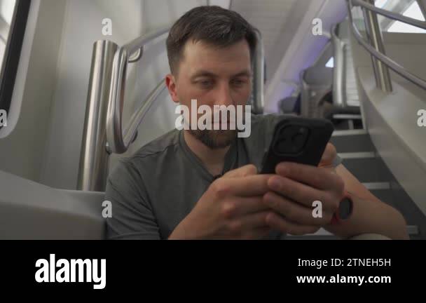 Young man travels on double decker train and sits on flyer using his ...