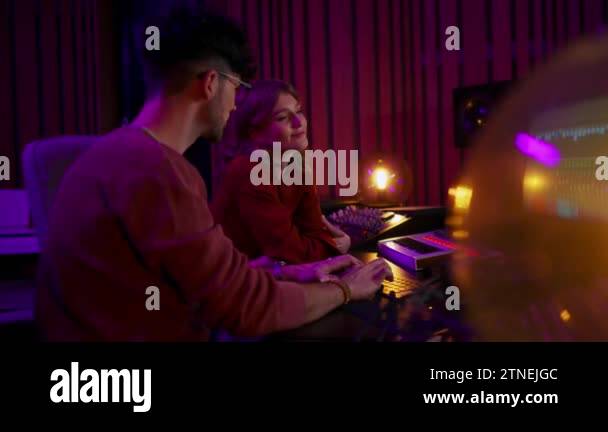 Male producer and young singer woman creating music track using mixing ...