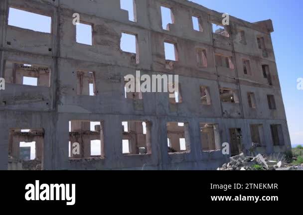 Large ruined building with pile of construction debris and concrete ...