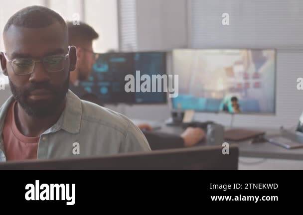 Two multiethnic video game developers working on fps game on computers ...