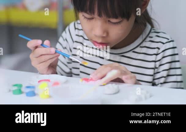 Cute little girl making DIY plaster and painting at home. Children ...